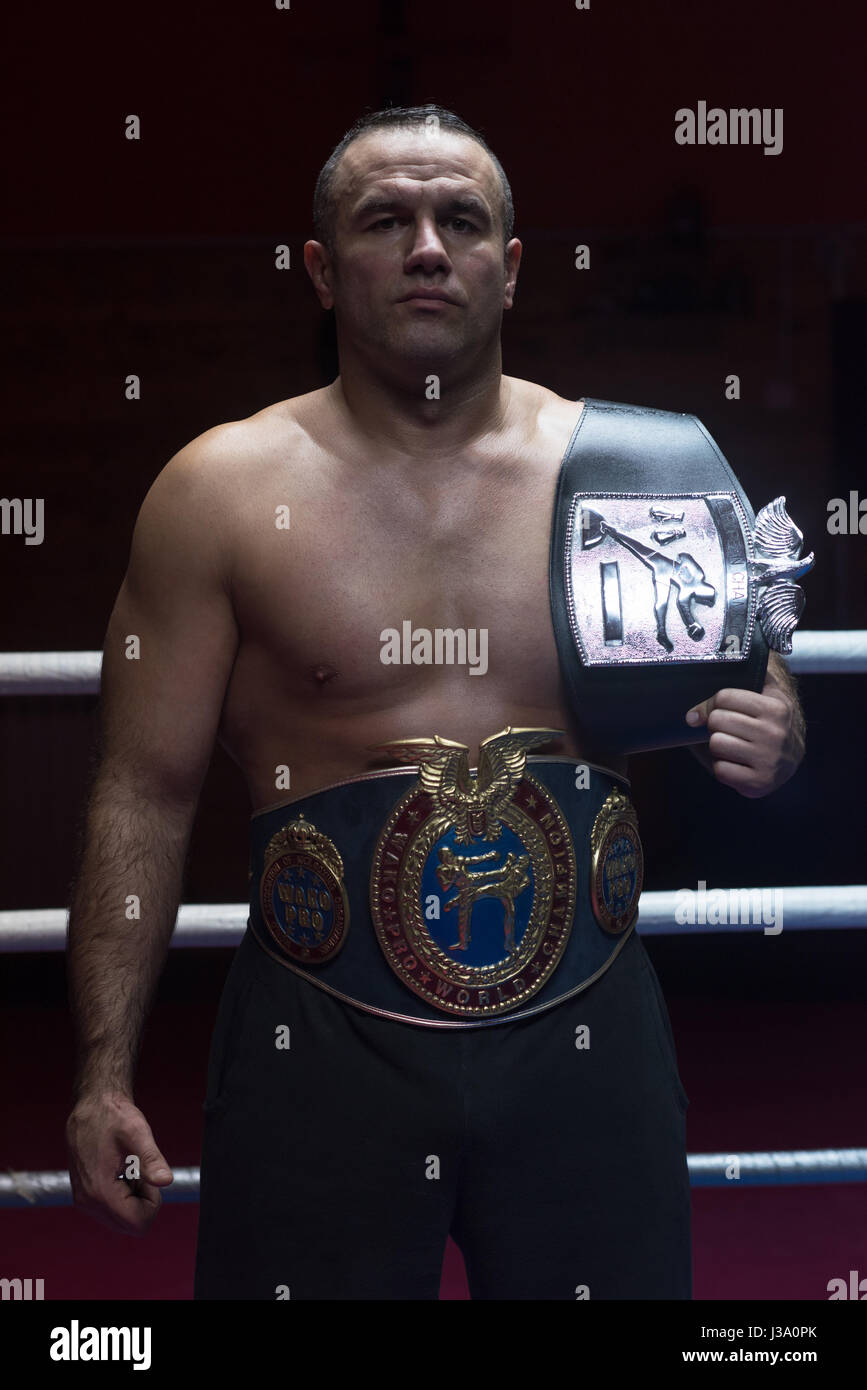portrait of muscular professional kick boxer with his championship belt ...