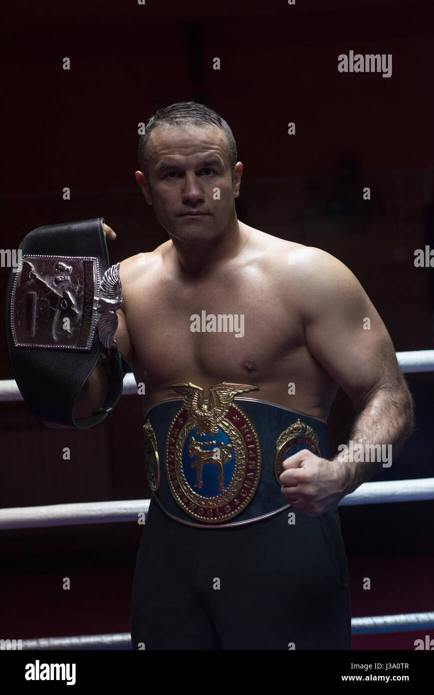 portrait of muscular professional kick boxer with his championship belt ...