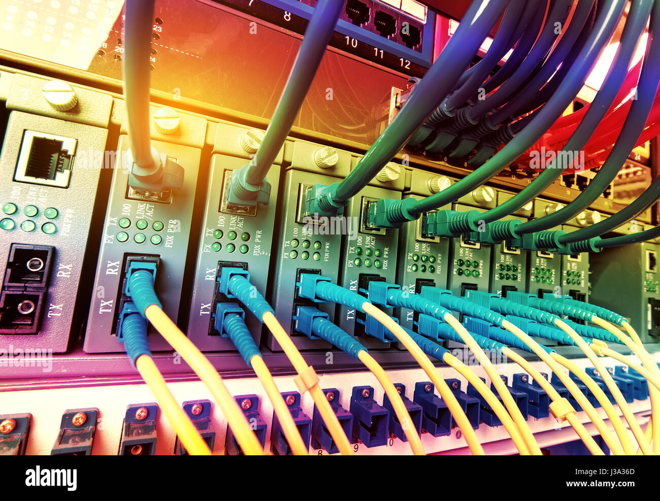 Fiber Optic cables connected to an optic ports and Network cables ...