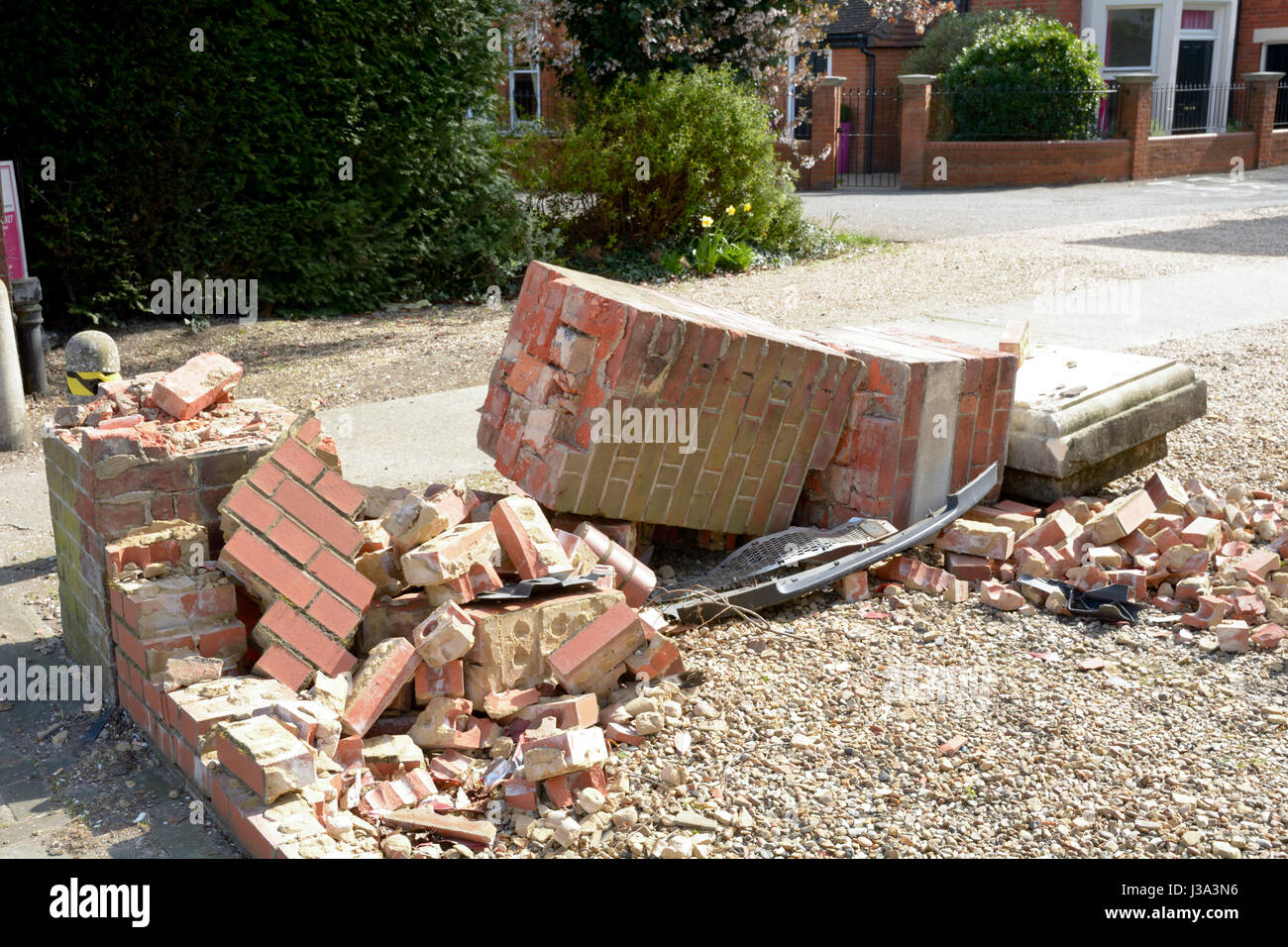 Wall destroyed by car with car bumper riped off in the impact and part ...