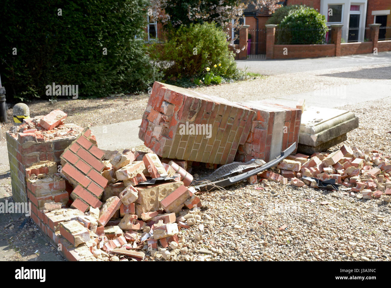Wall destroyed by car with car bumper riped off in the impact and part ...