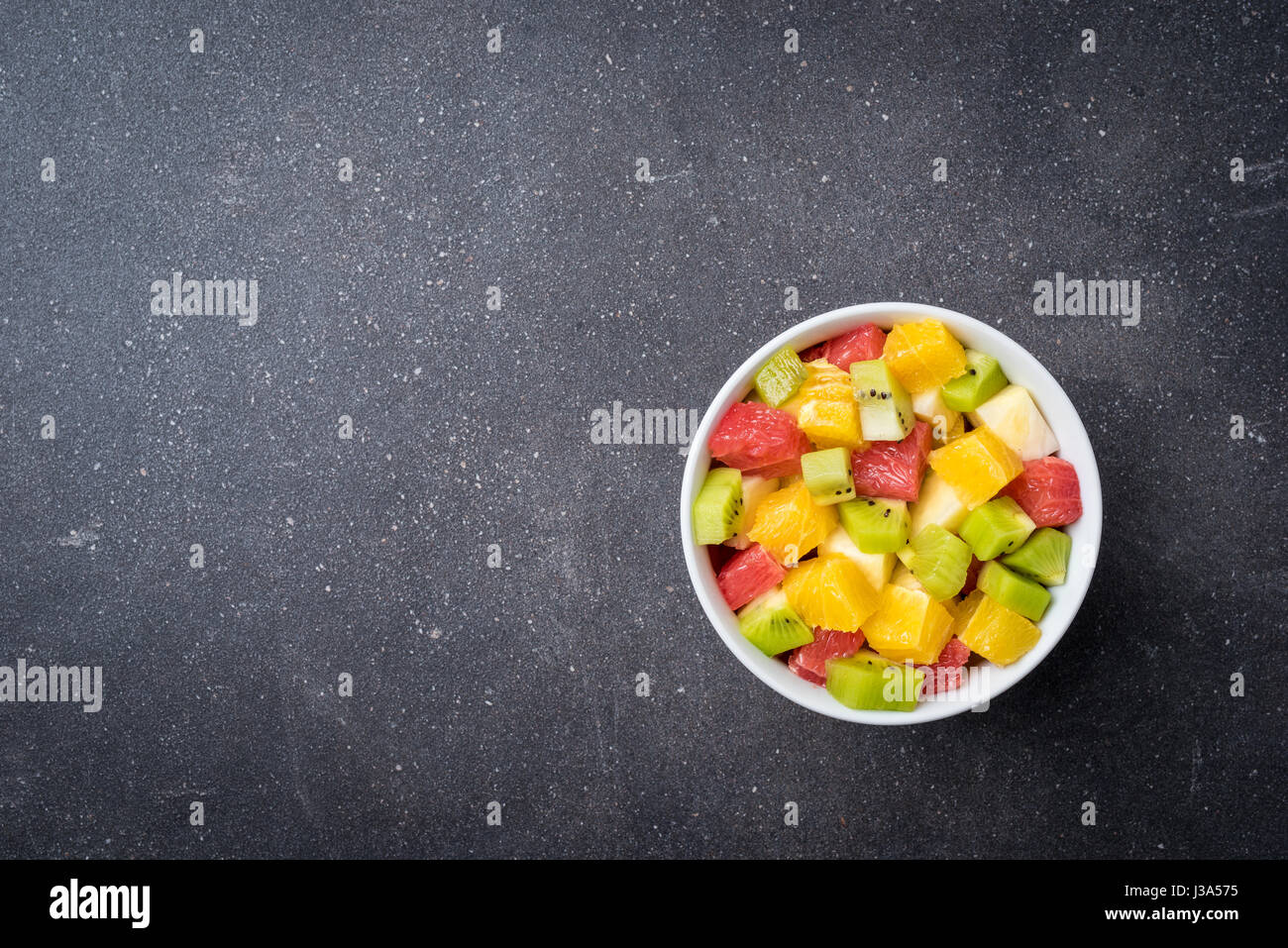 Colorful fruit salad on gray stone table. Food background Stock Photo ...