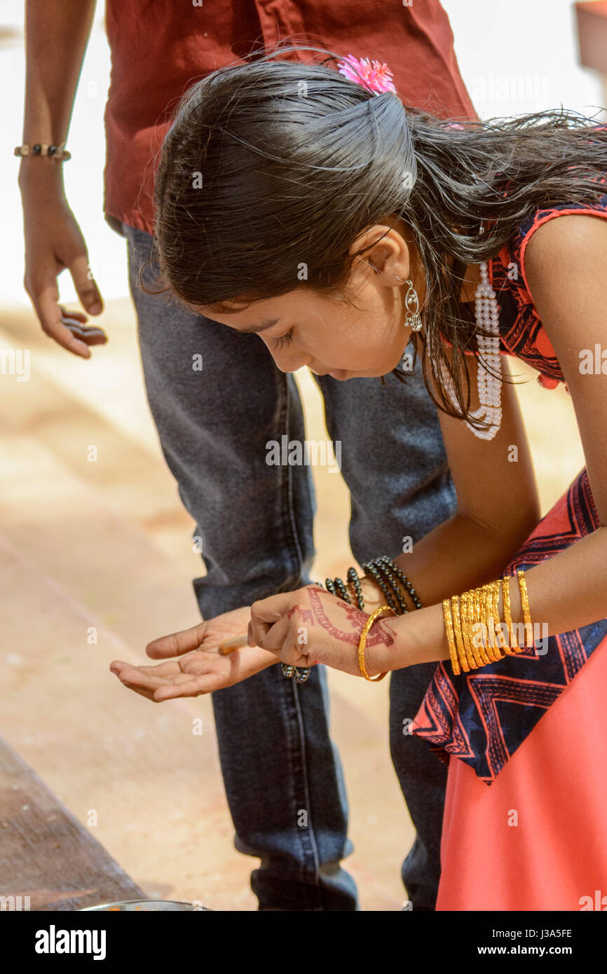 Young girl painting her hand at a traditional Theyyam festival - a ...