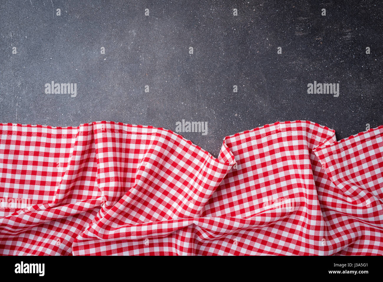 Red folded tablecloth on gray stone table. Food background Stock Photo ...