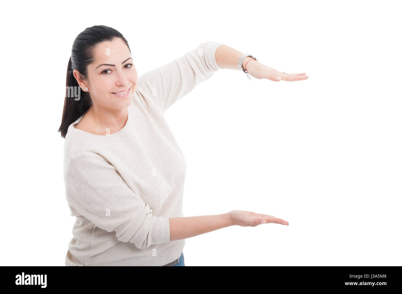 Pretty woman holding something invisible and big in her palms with ...