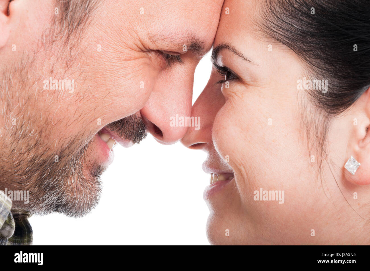 Romantic young couple touching their foreheads in close up and sharing ...