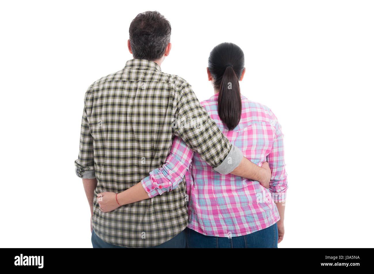 Rear view of young couple standing and holding together on white ...