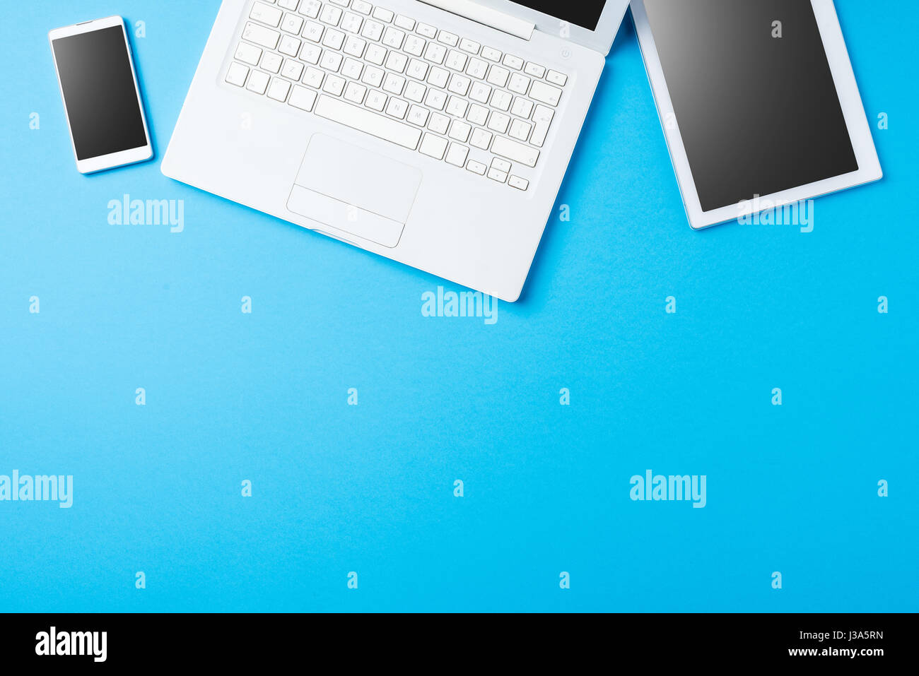 Digital devices on blue background Stock Photo - Alamy