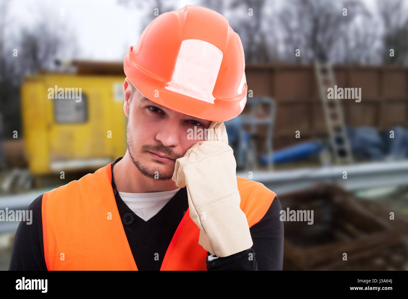 Closeup portrait of attractive builder thinking at something on ...