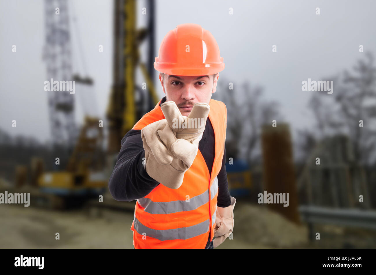 Attractive builder doing I'm watching you gesture as intimidation ...