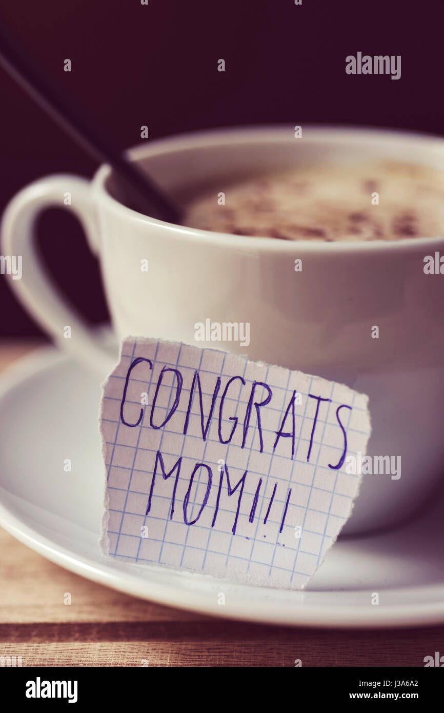 closeup of a piece of paper with the text congrats mom written in it ...