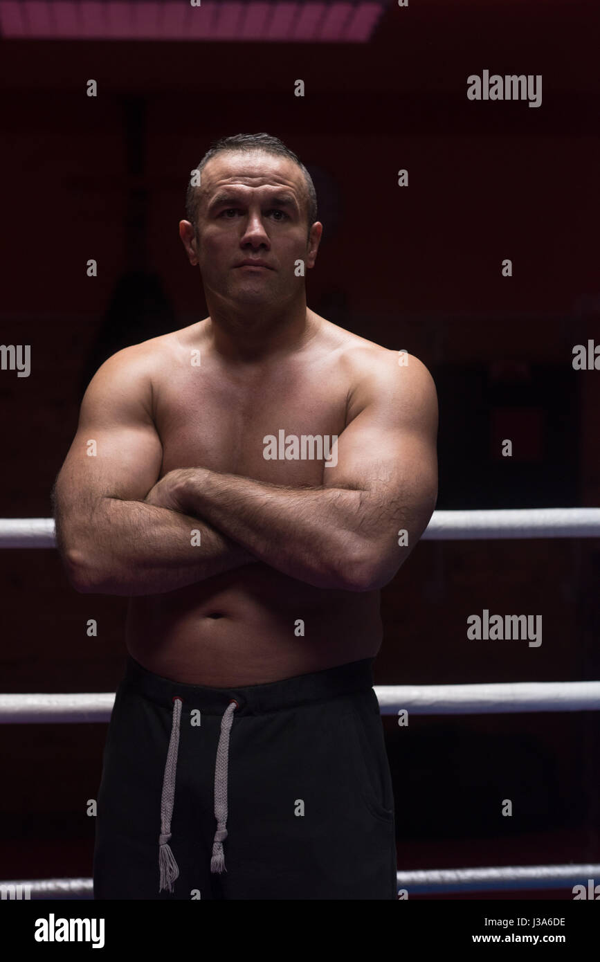portrait of muscular professional kickboxer with arms crossed in the ...