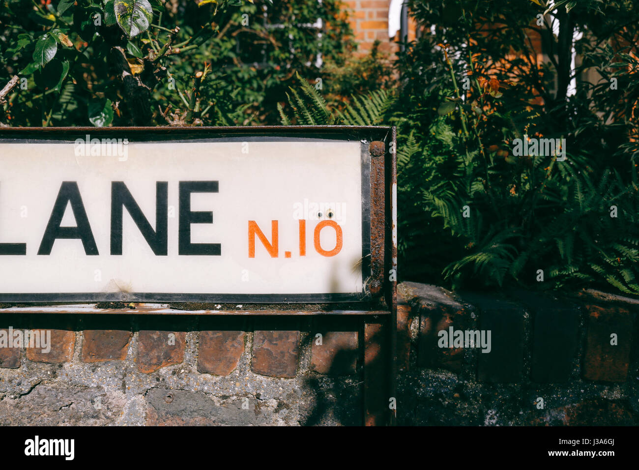 Plastic eyes placed over zero in postcode on the street sign in Muswell ...