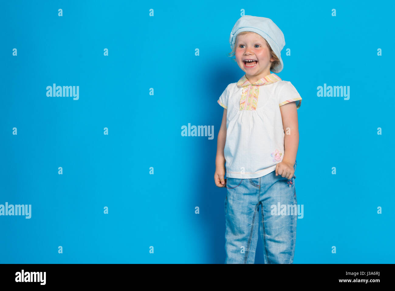Portrait of beautiful little girl against blue background Stock Photo ...