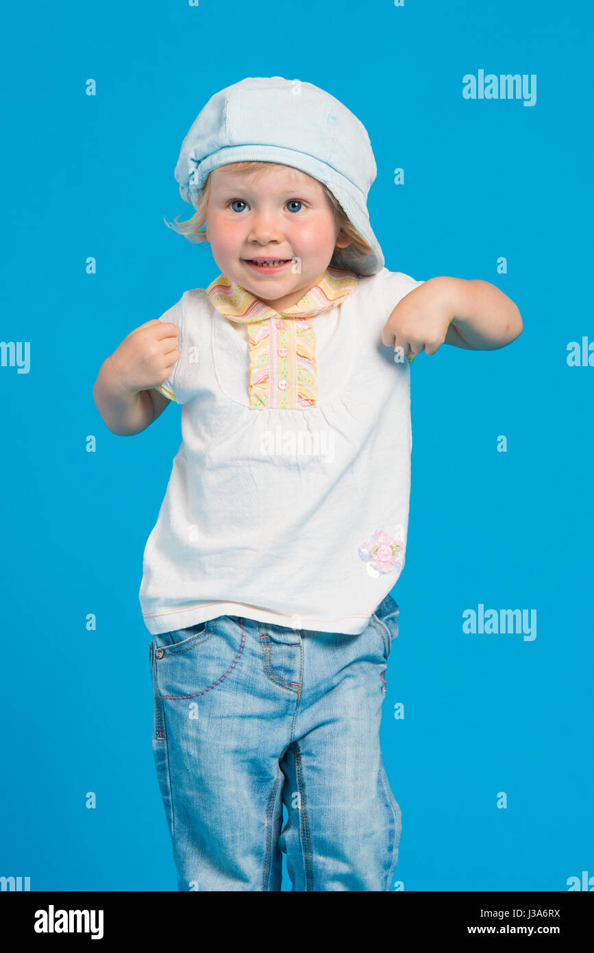 Portrait of beautiful little girl against blue background Stock Photo ...