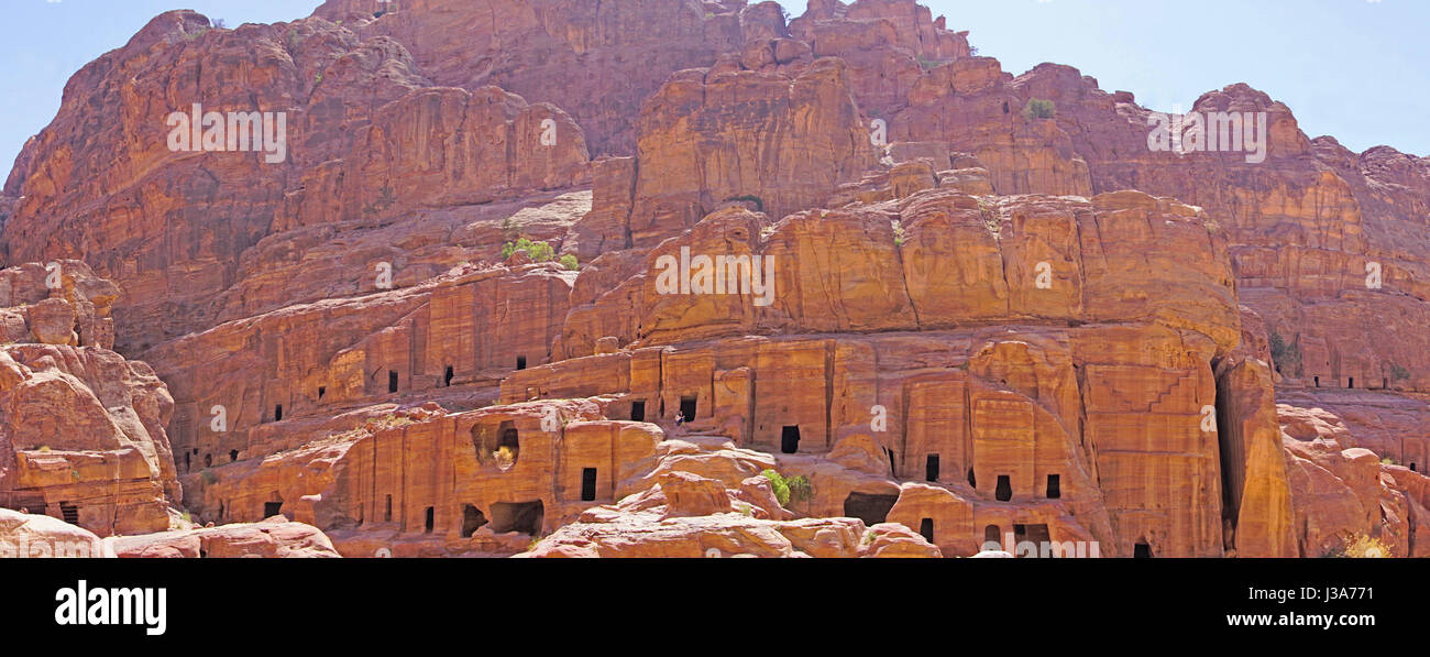 Panorama of facades sculpted into sandstone cliffs at Petra along ...