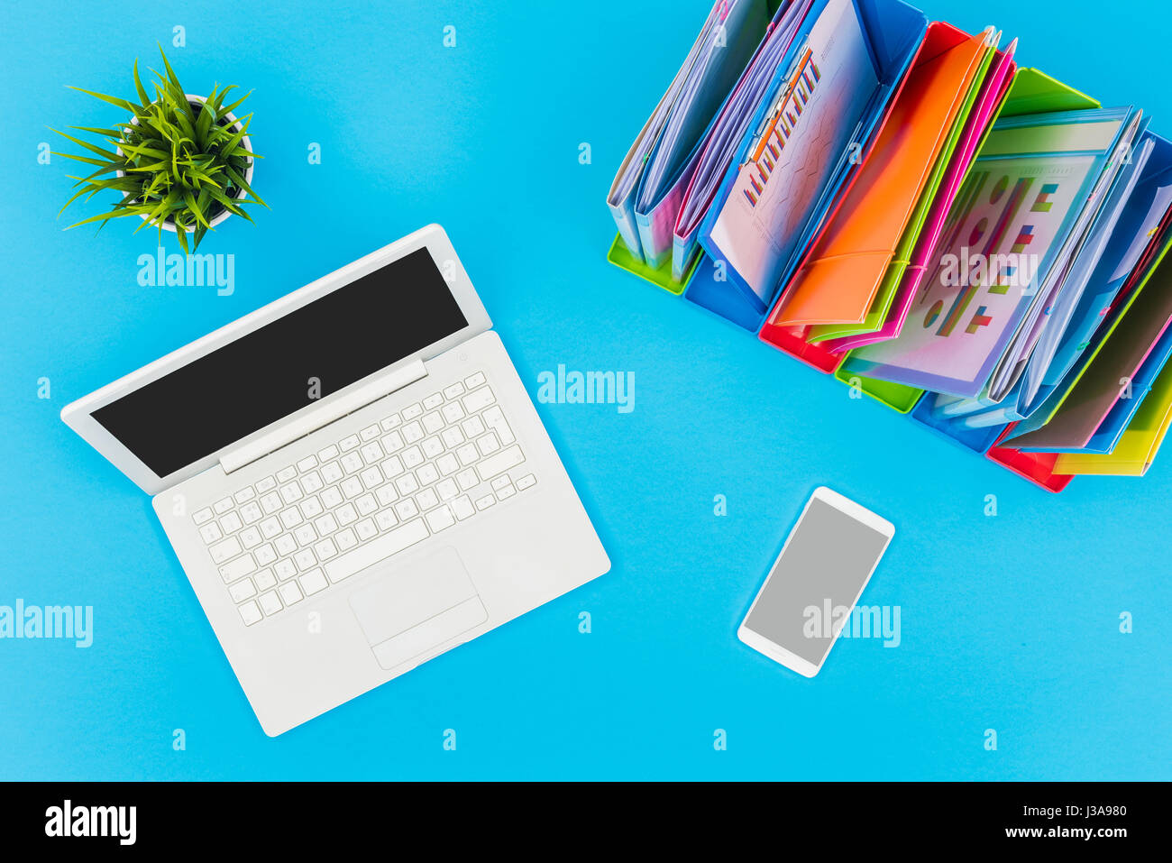 Blue office table with laptop and documents Stock Photo - Alamy