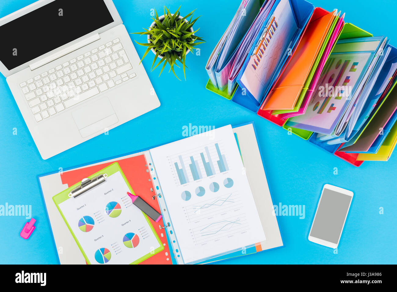 Blue office table with laptop and documents Stock Photo - Alamy