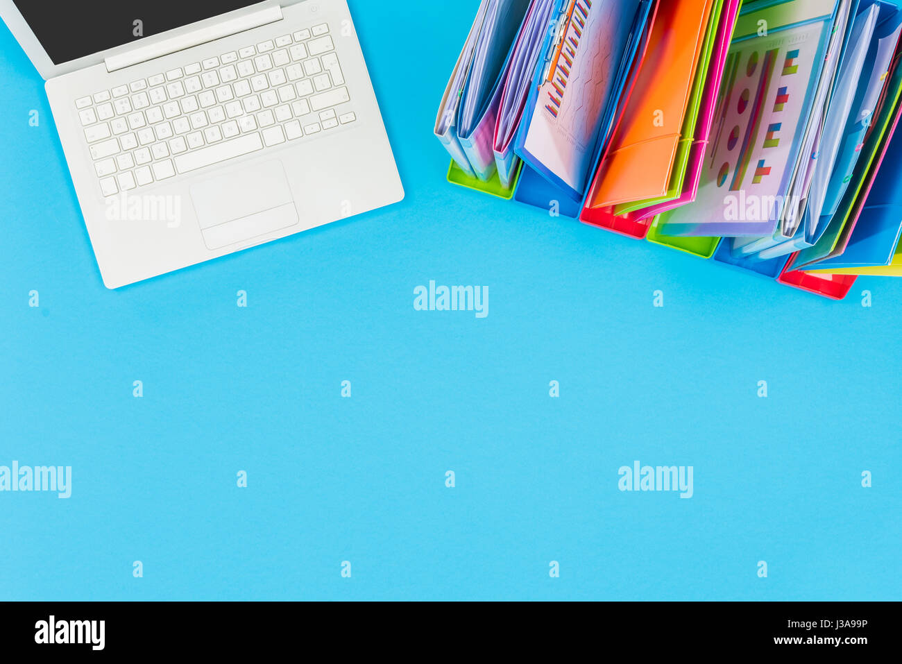 Blue office table with laptop and documents Stock Photo - Alamy