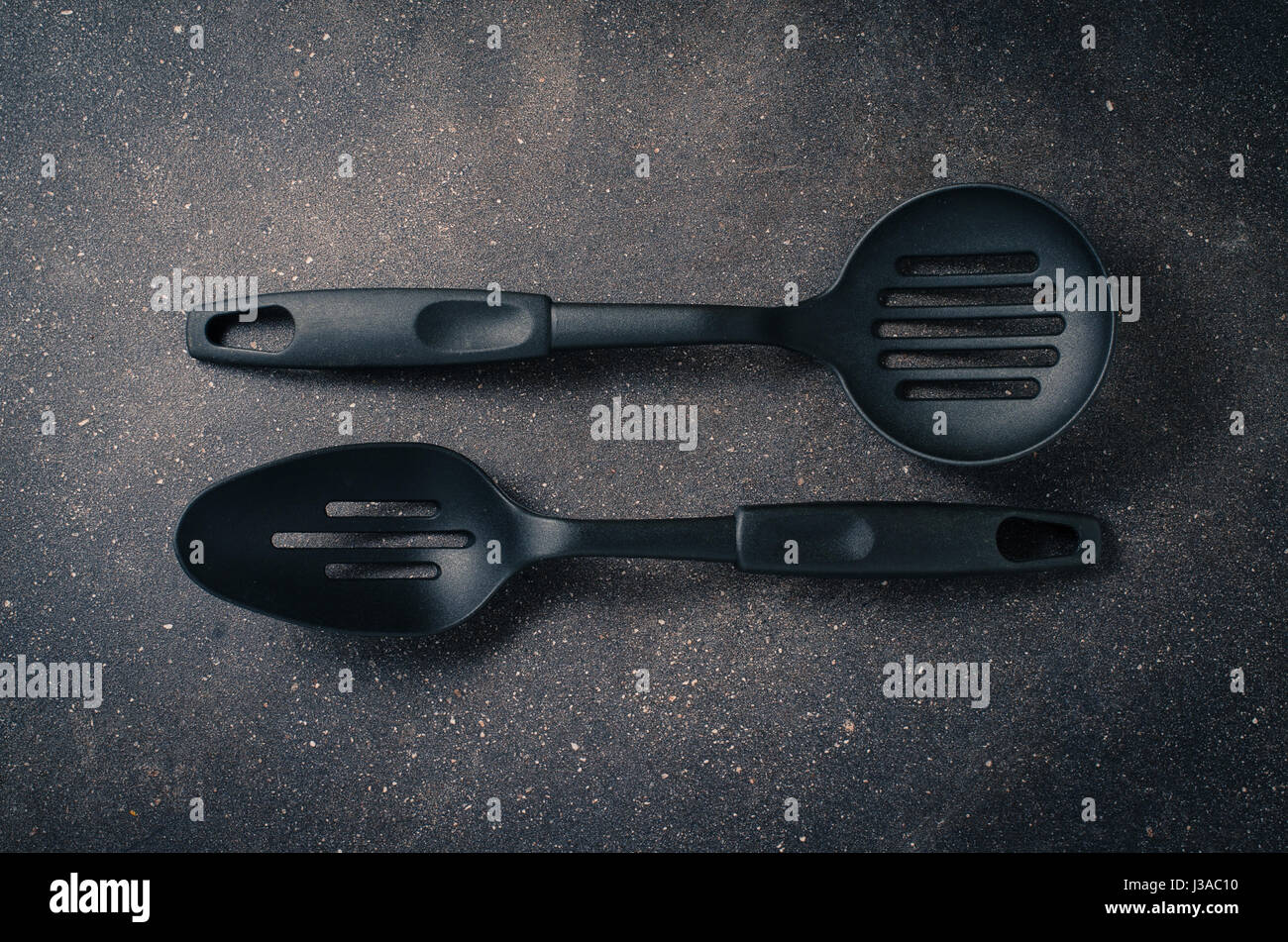 Black kitchen spoons on dark table Stock Photo - Alamy