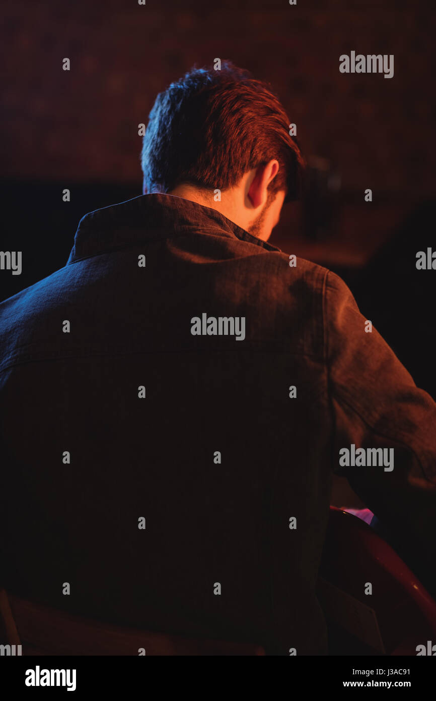 Rear view of man playing guitar in pub Stock Photo - Alamy
