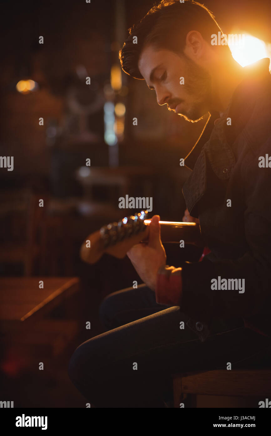 Young man playing guitar in pub Stock Photo - Alamy