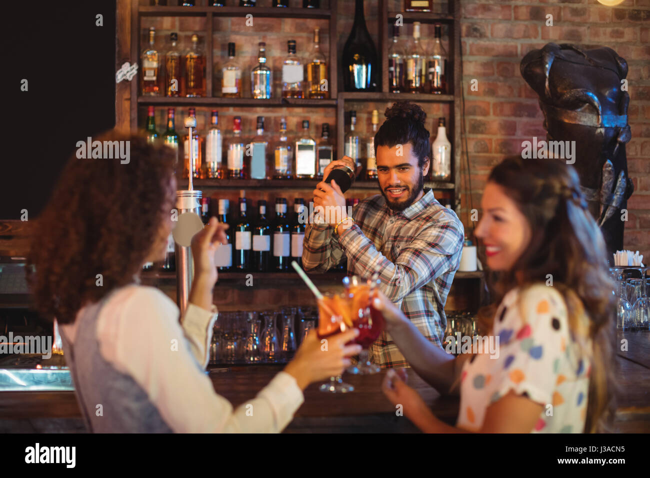 Bartender mixing a cocktail drink in cocktail shaker at pub Stock Photo ...