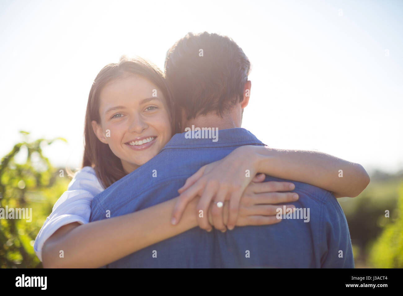 Happy woman hugging her boyfriend at farm during sunny day Stock Photo - Alamy