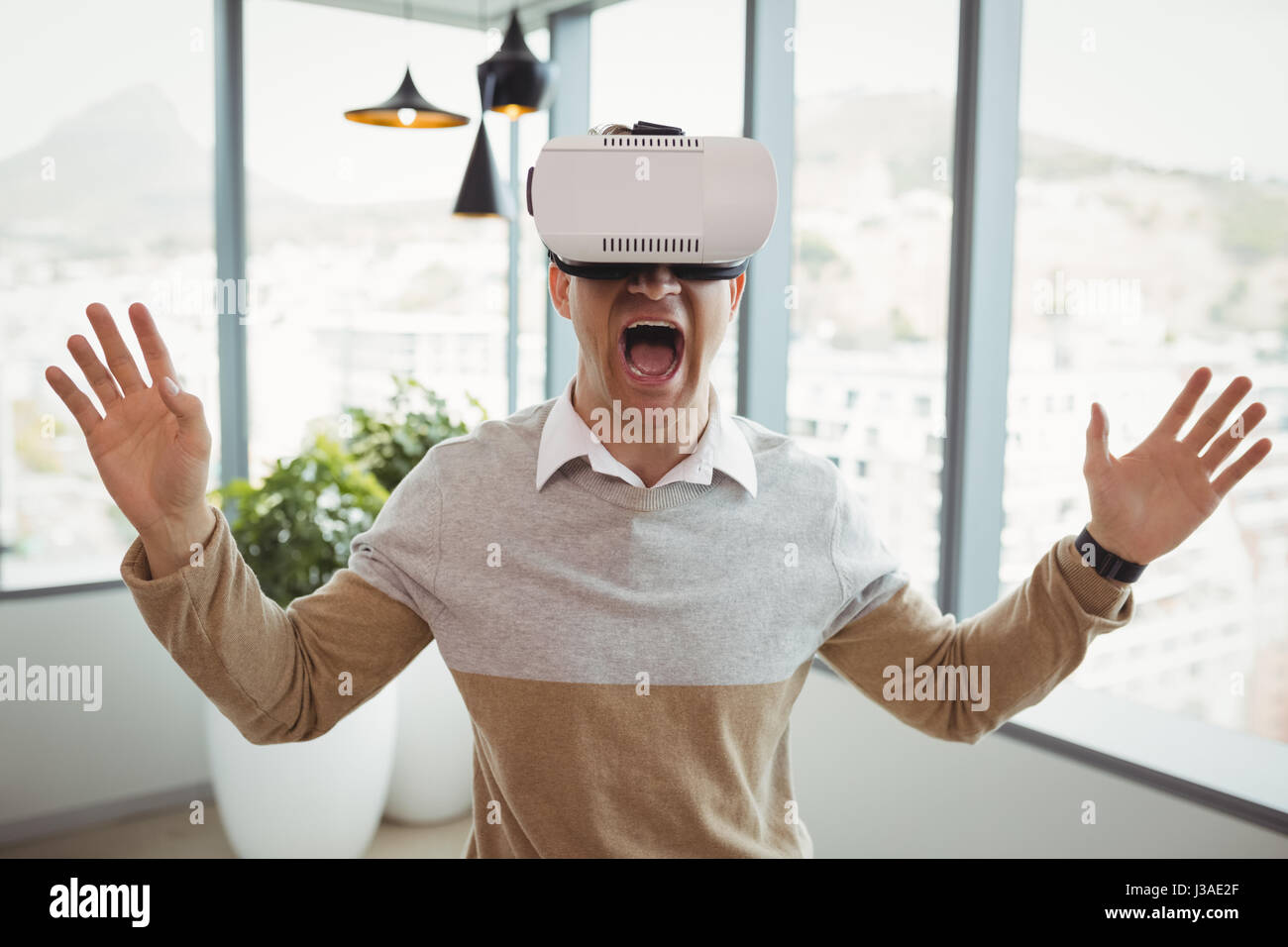 Happy executive using virtual reality headset in office Stock Photo - Alamy