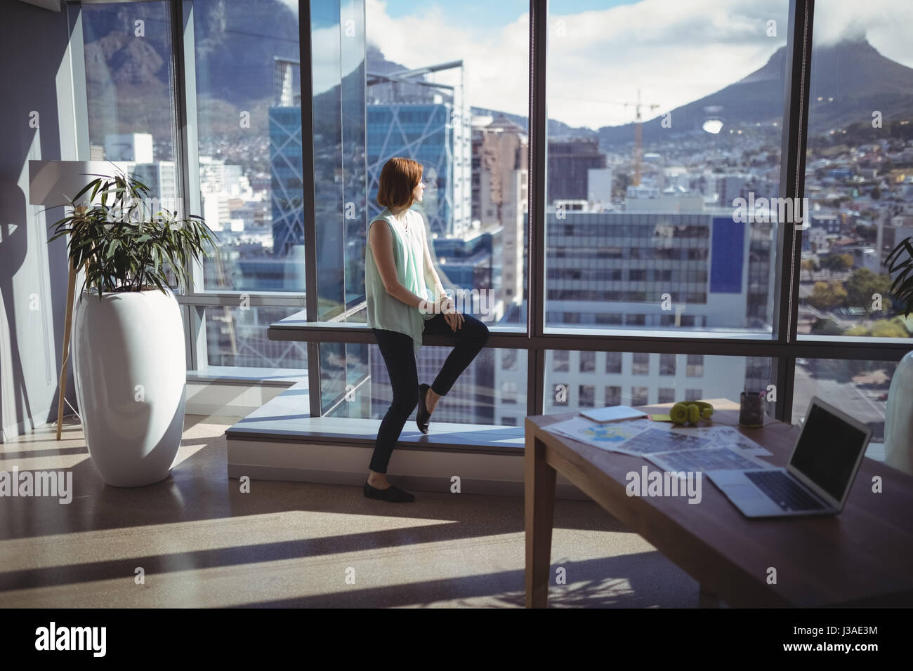Thoughtful executive looking through window in office Stock Photo - Alamy