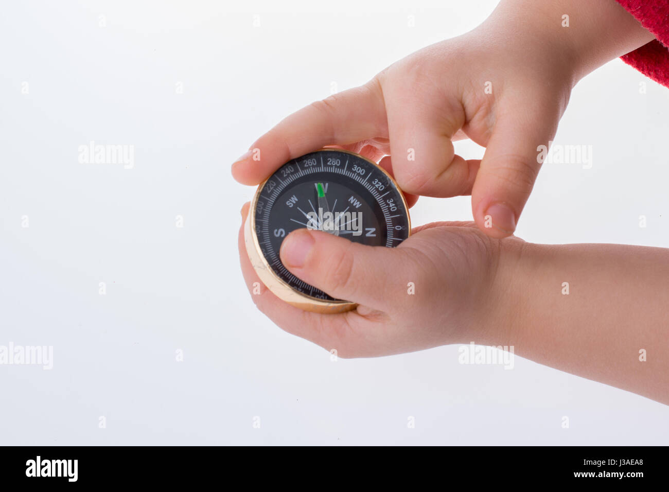Child hand holding a compass on a white background Stock Photo - Alamy