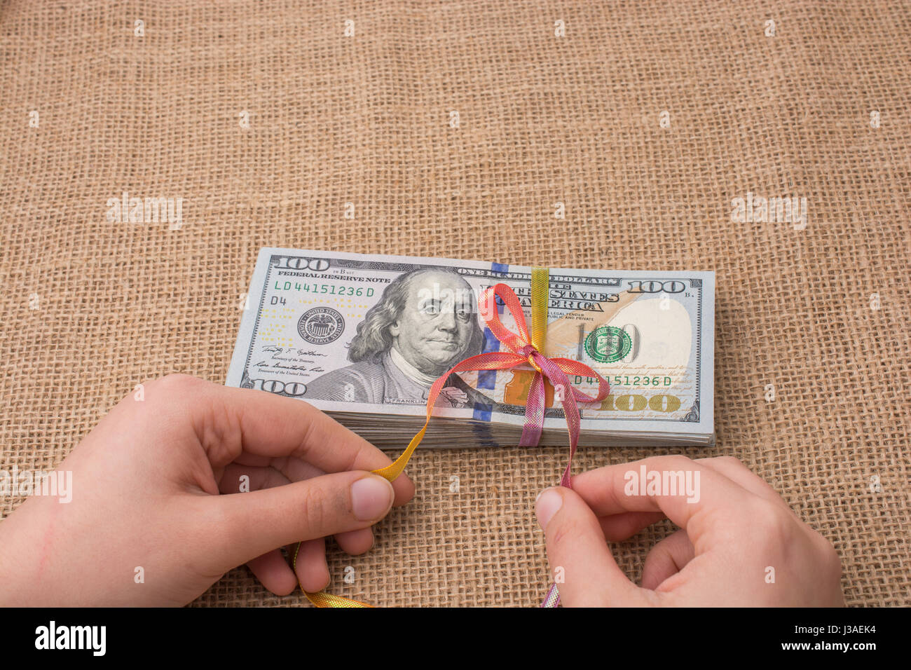 Banknote bundle of US dollar tied with colorful a ribbon Stock Photo ...