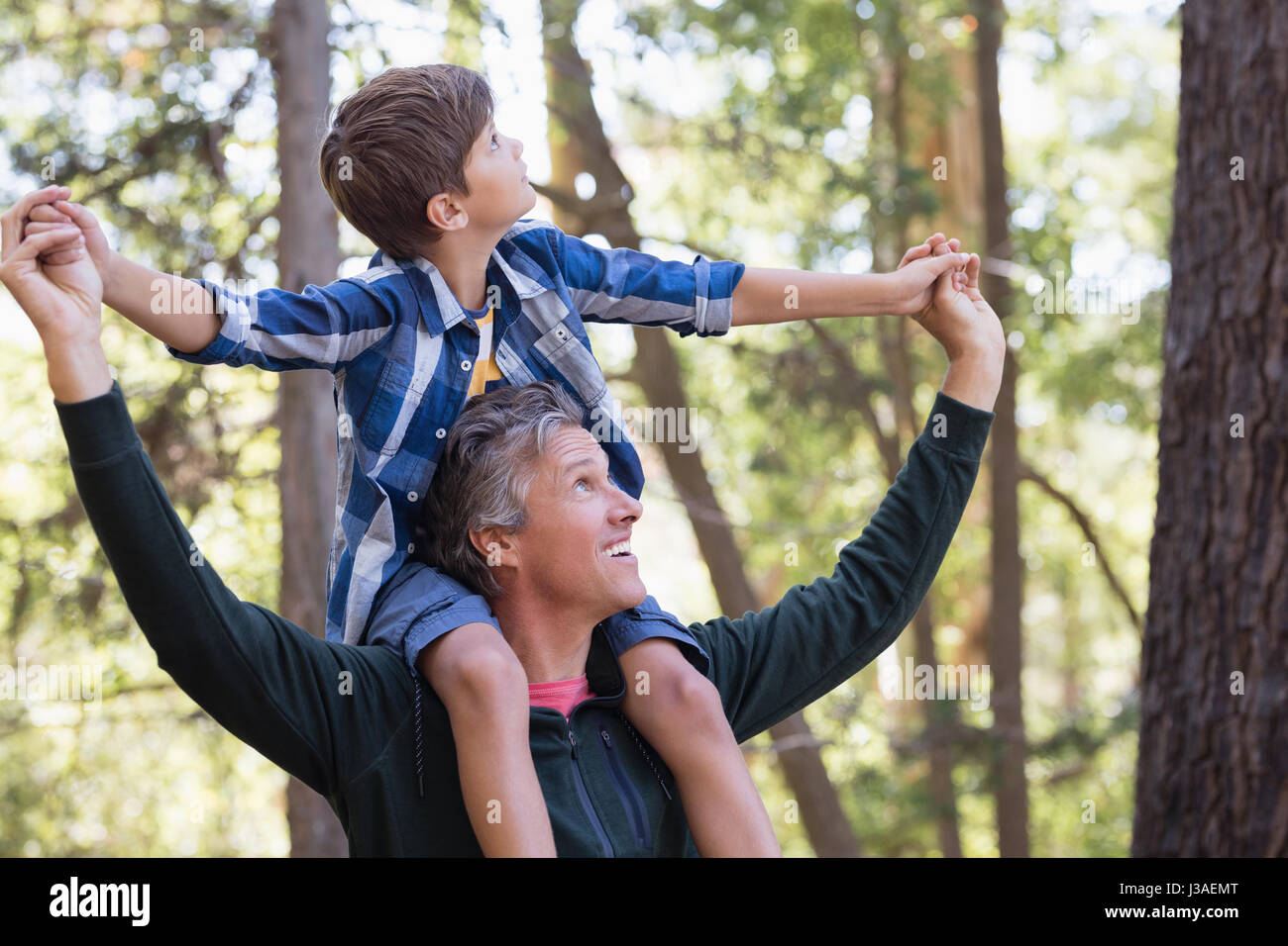 Happy father carrying son on shoulders while hiking in forest Stock ...