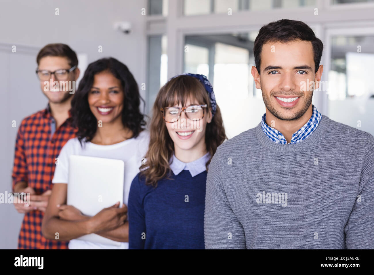 Portrait of smiling colleagues standing in office Stock Photo - Alamy