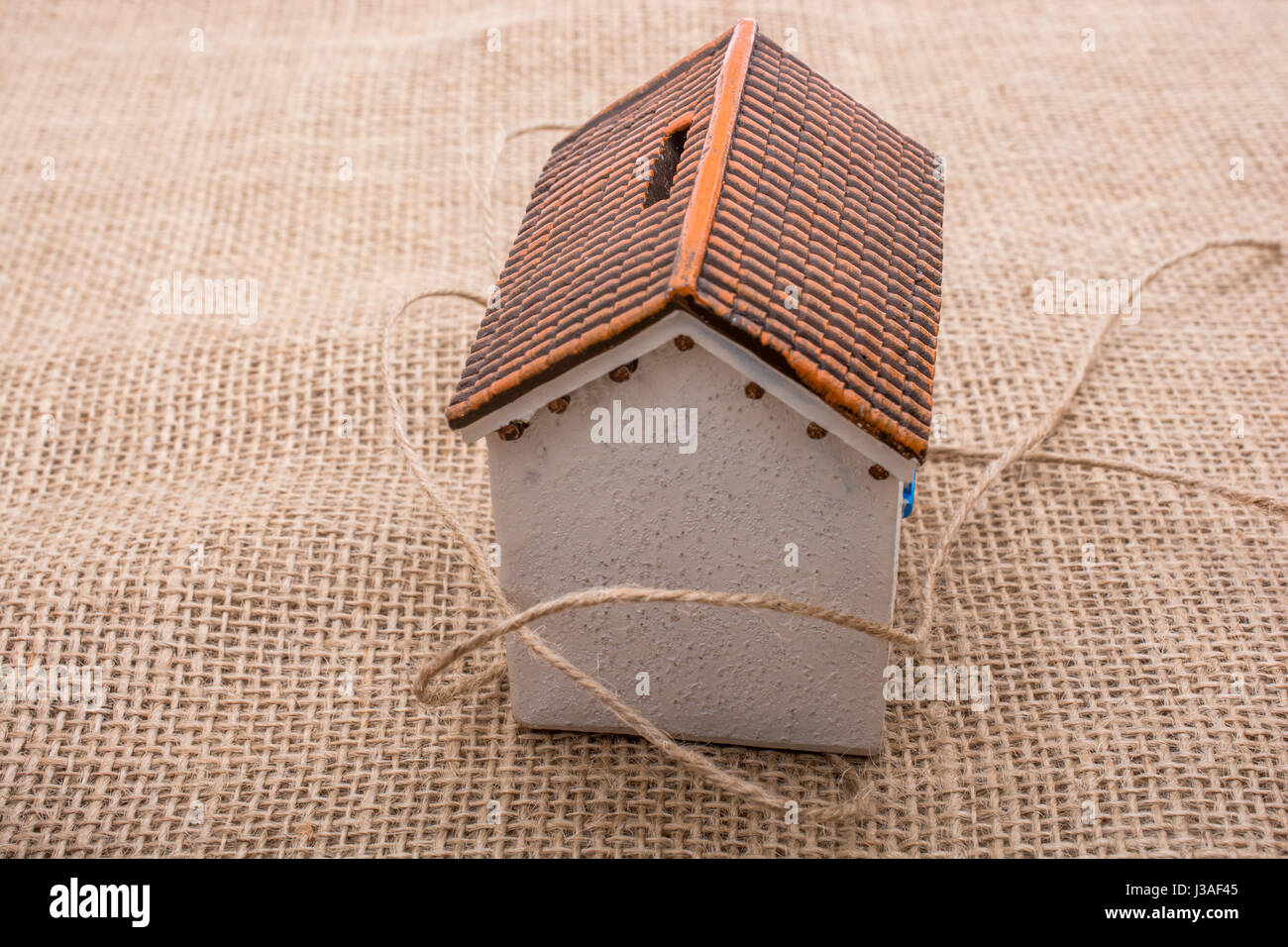 Thread wrapped around a model house on a brown background Stock Photo ...