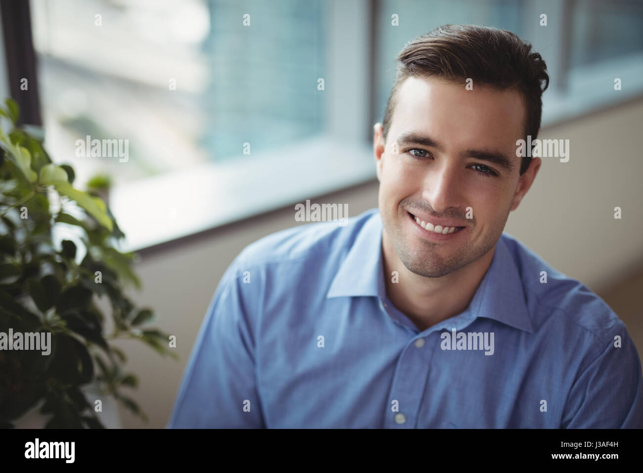 Portrait of smiling executive sitting in office Stock Photo - Alamy