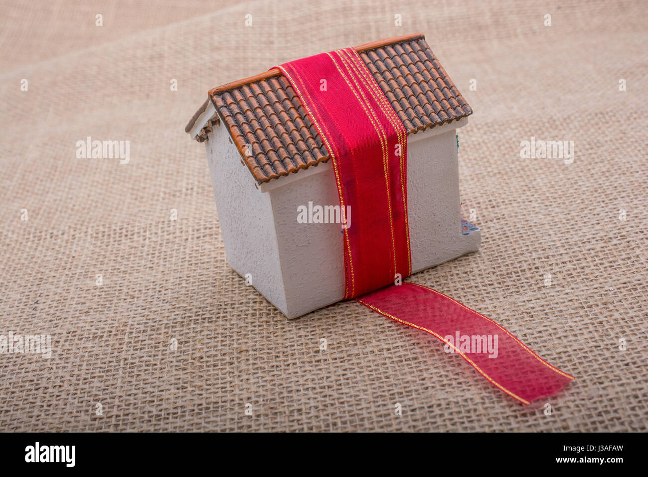 Pink band wrapped around a model house on a brown background Stock ...