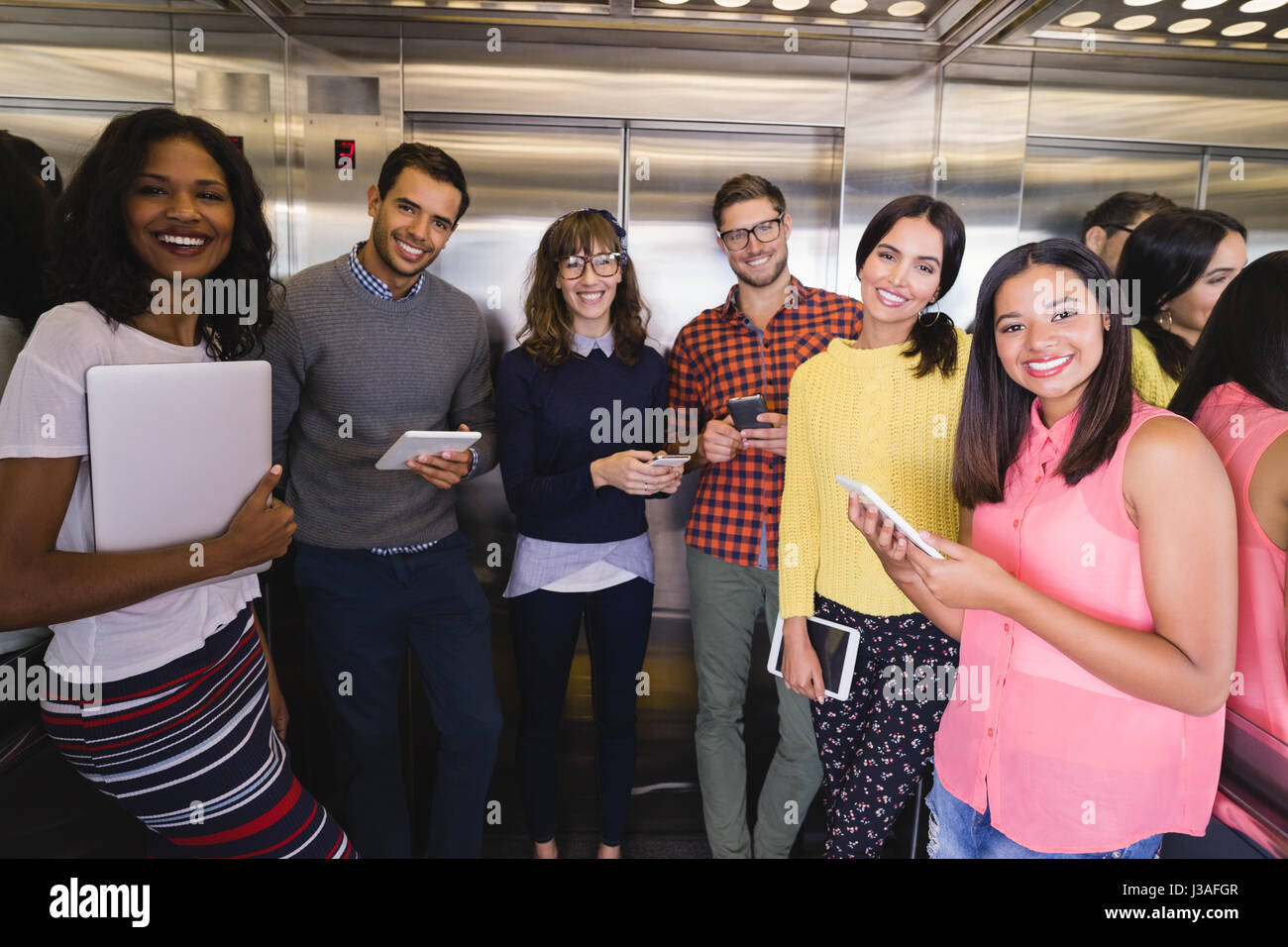 Portrait of smiling business people standing in elevator Stock Photo ...