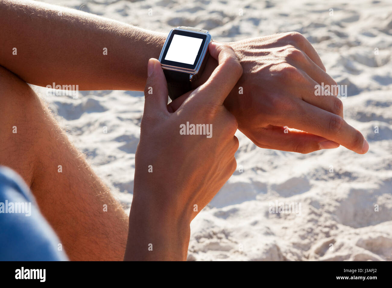 Close-up of man checking his smartwatch on the beach Stock Photo - Alamy