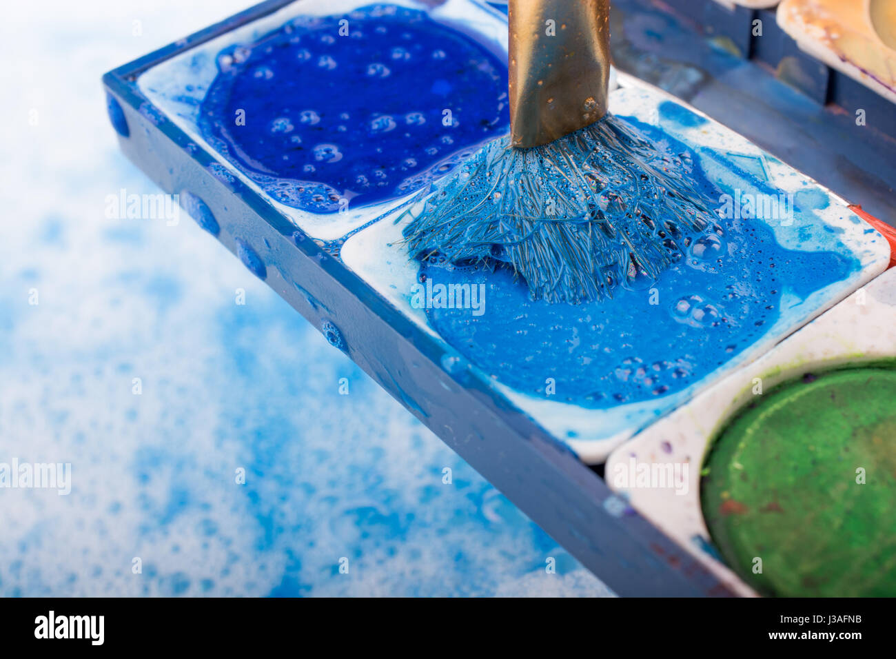 Watercolor paint dissolving in water covered with foam Stock Photo - Alamy