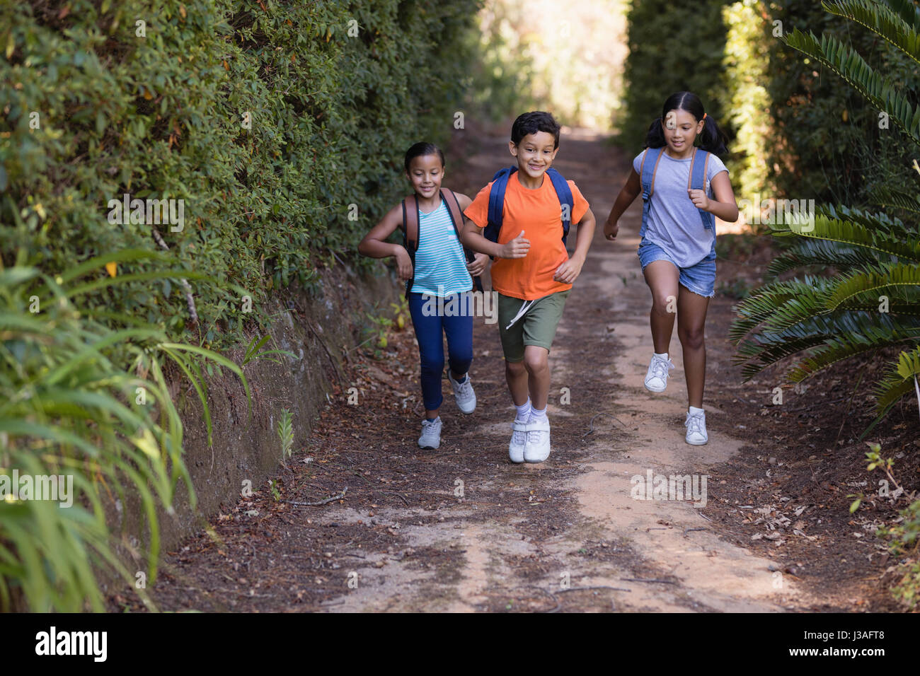 Full length of friends running on field at natural parkland Stock Photo ...