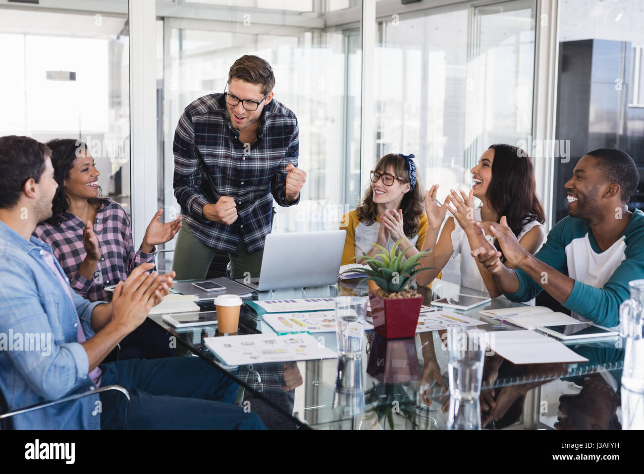 Cheerful creative business team around glass table at office Stock ...