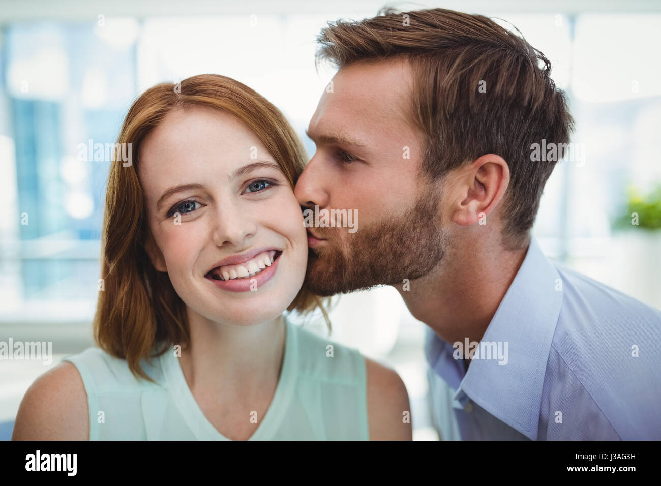 Affectionate man kissing woman in office Stock Photo - Alamy