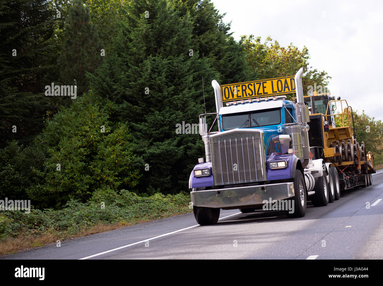 The big powerful rig semi truck with a sign Oversize load on the cab ...