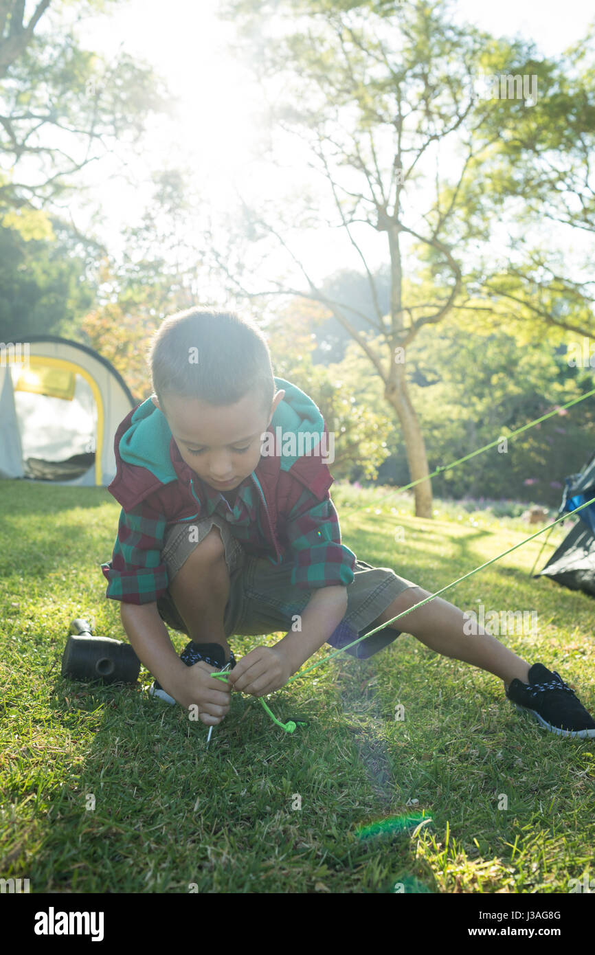 Boy setting up the tent at campsite on a sunny day Stock Photo - Alamy