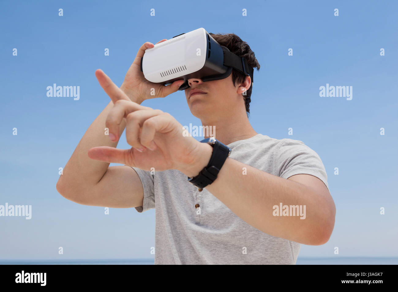 Close-up of man using vr headset against the blue sky Stock Photo - Alamy
