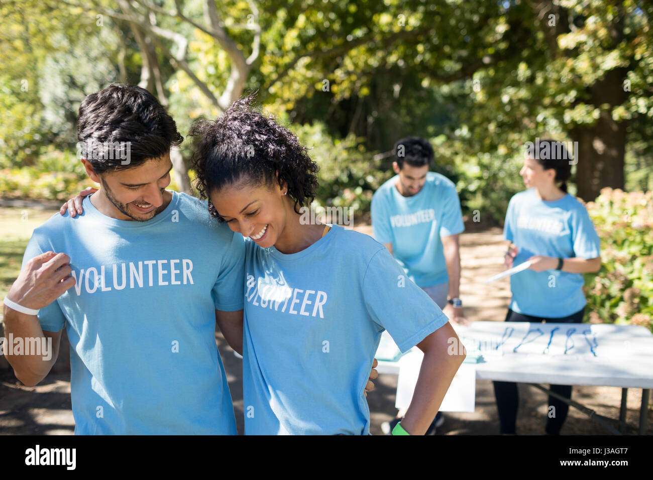 Smiling volunteers talking to each other in the park Stock Photo - Alamy