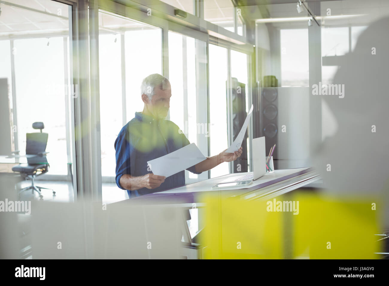 Male interior designer analyzing diagrams on papers in creative office ...