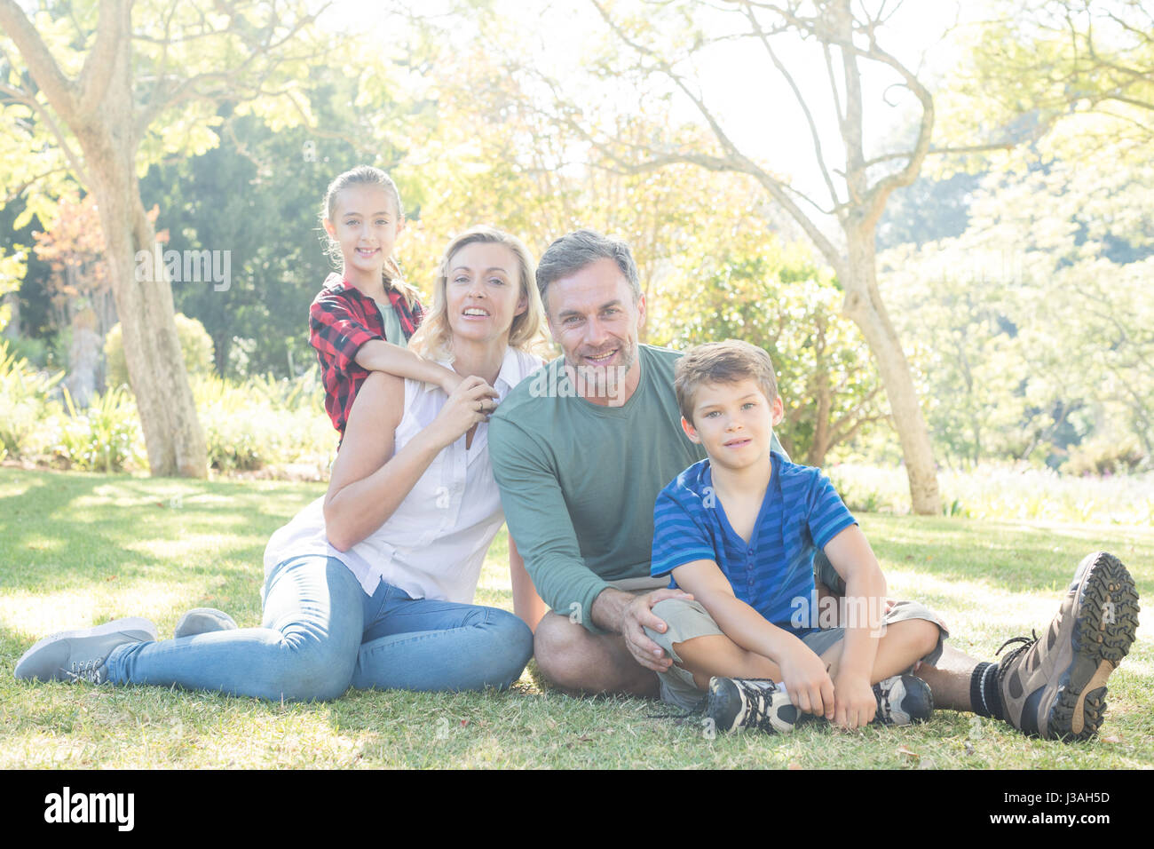 Portrait of happy family in park on a sunny day Stock Photo - Alamy