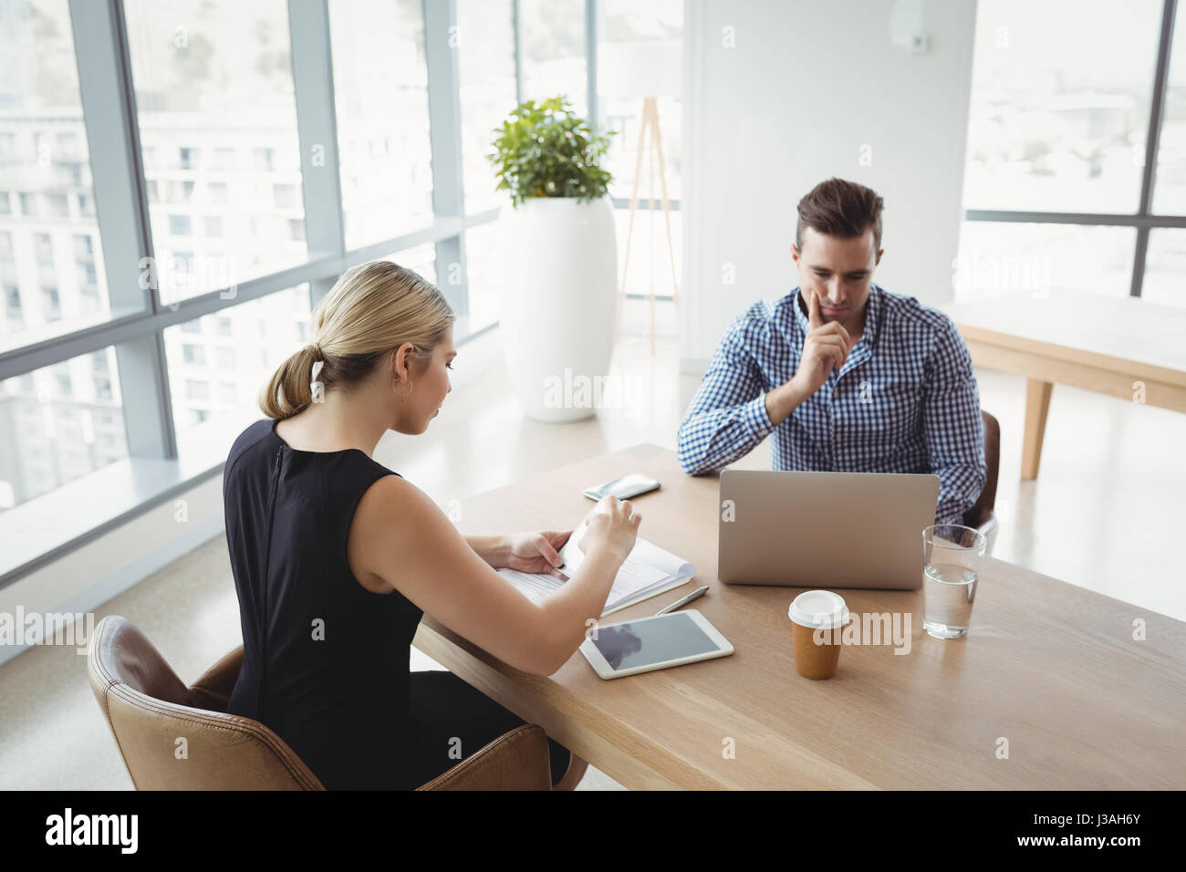 Attentive executives working at desk in office Stock Photo - Alamy
